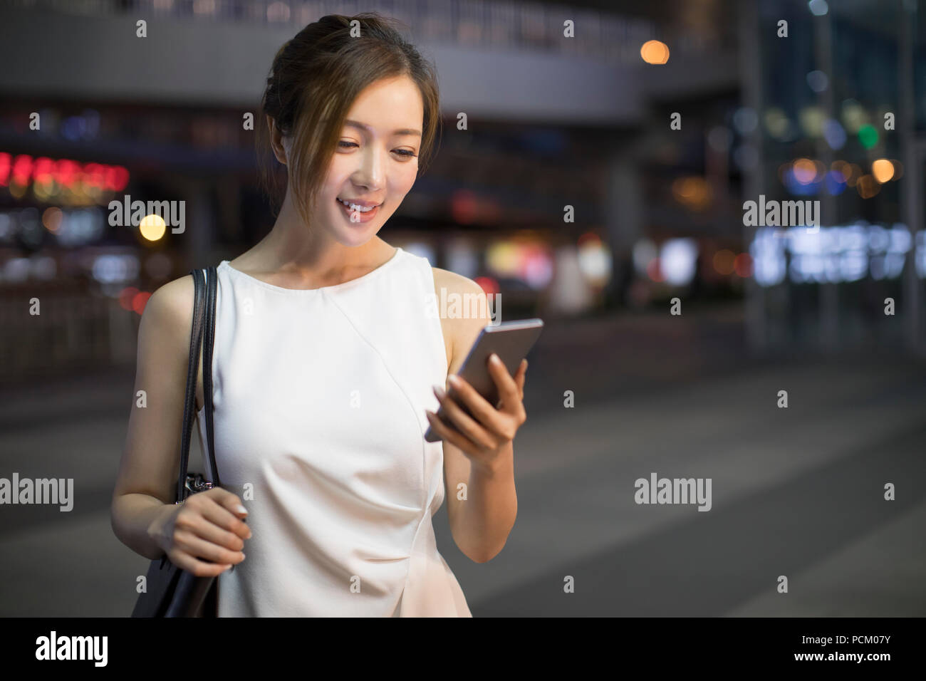 Cheerful young Chinese businesswoman using smart phone Stock Photo - Alamy