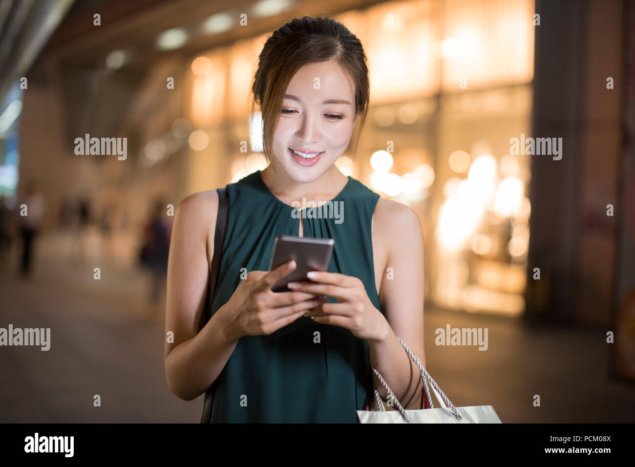 Cheerful young Chinese woman using smart phone Stock Photo - Alamy