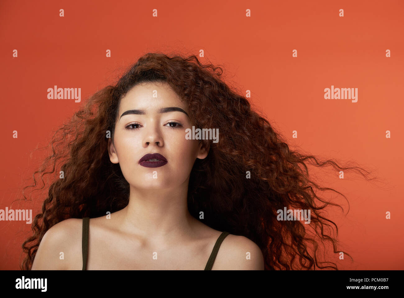Portrait of young healthy woman on orange color background Stock Photo ...
