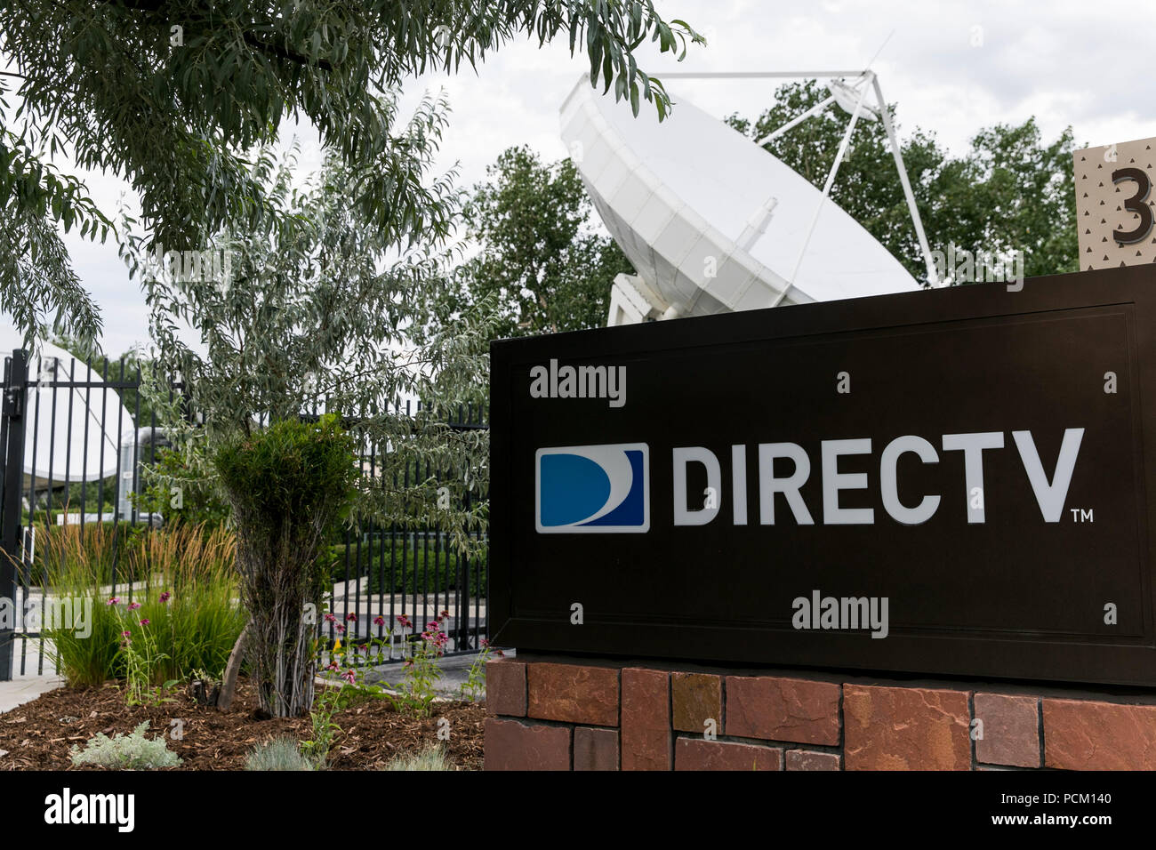 A logo sign outside of a facility occupied by DirecTV in Englewood ...