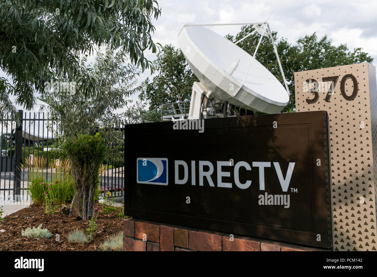 A logo sign outside of a facility occupied by DirecTV in Englewood ...
