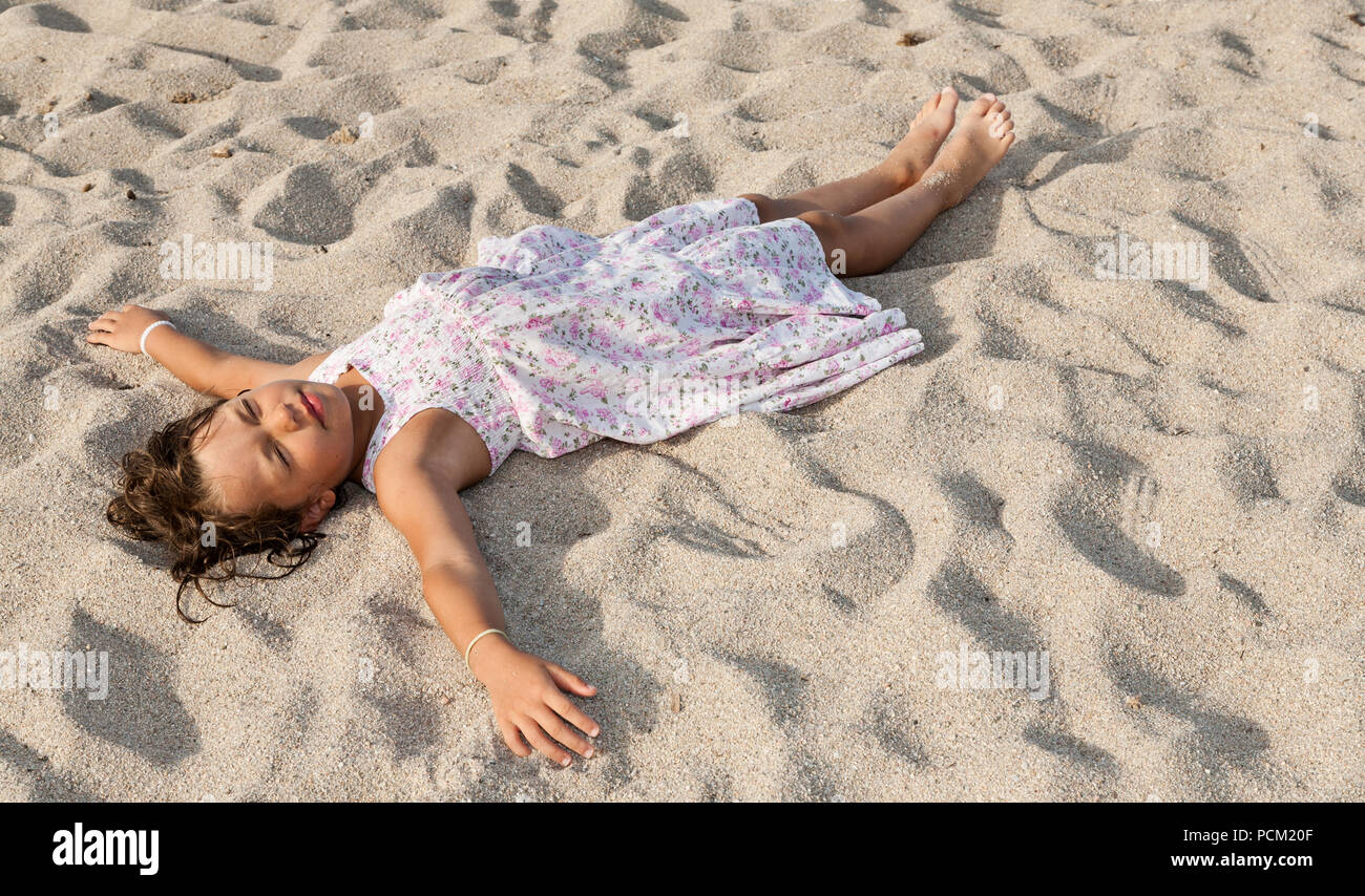 portrait of a little girl lying on the beach Stock Photo - Alamy