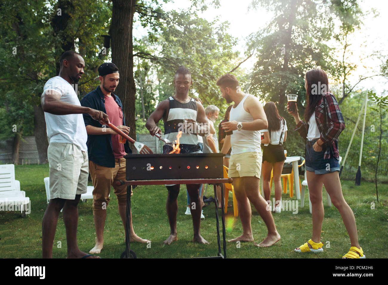 Group of friends making barbecue in the backyard. concept about good ...