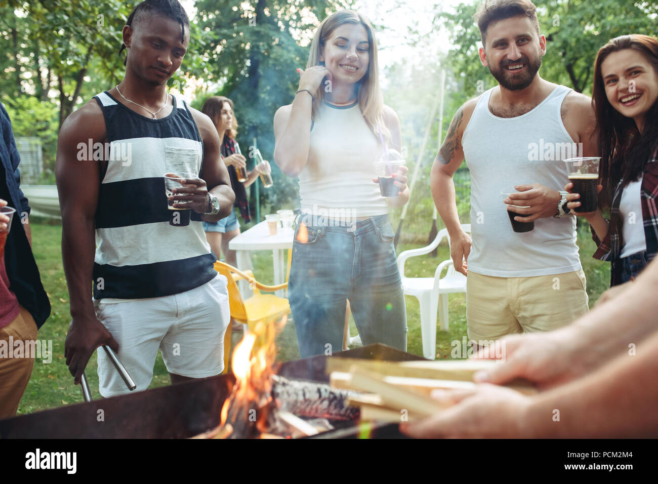 Group of friends making barbecue in the backyard. concept about good ...