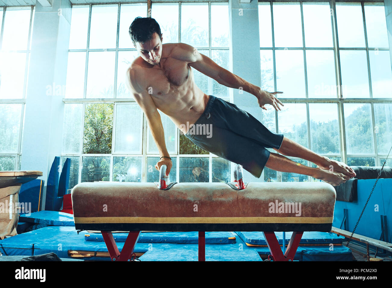 The sportsman during difficult exercise, sports gymnastics Stock Photo ...