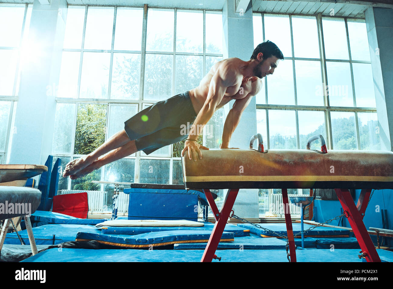 The sportsman during difficult exercise, sports gymnastics Stock Photo ...