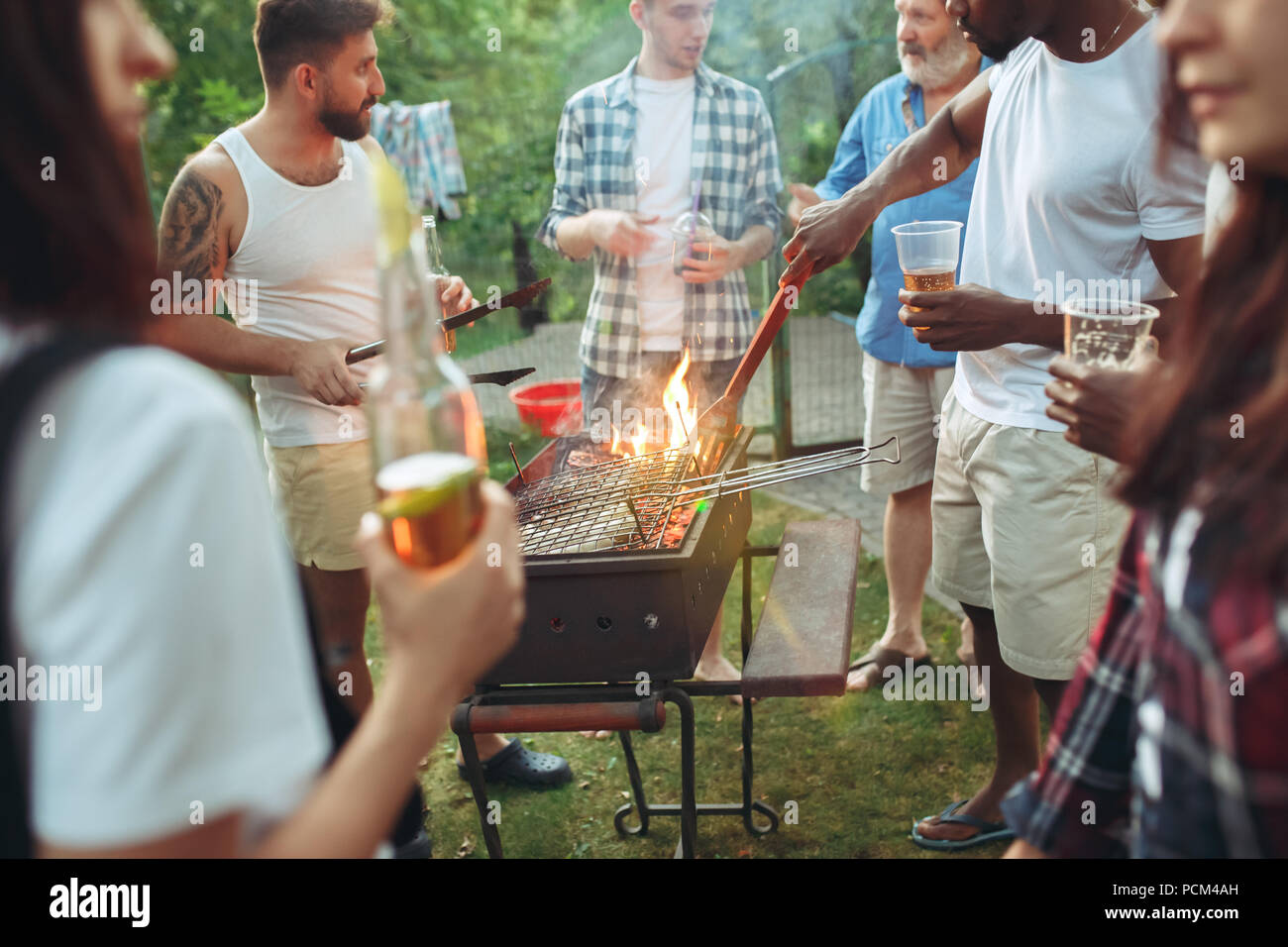 Group of friends making barbecue in the backyard. concept about good ...