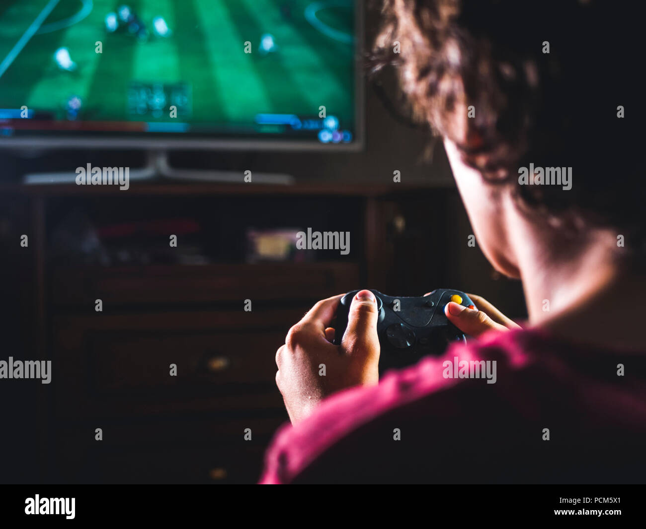 close up young man with joystick controller for console playing sport ...