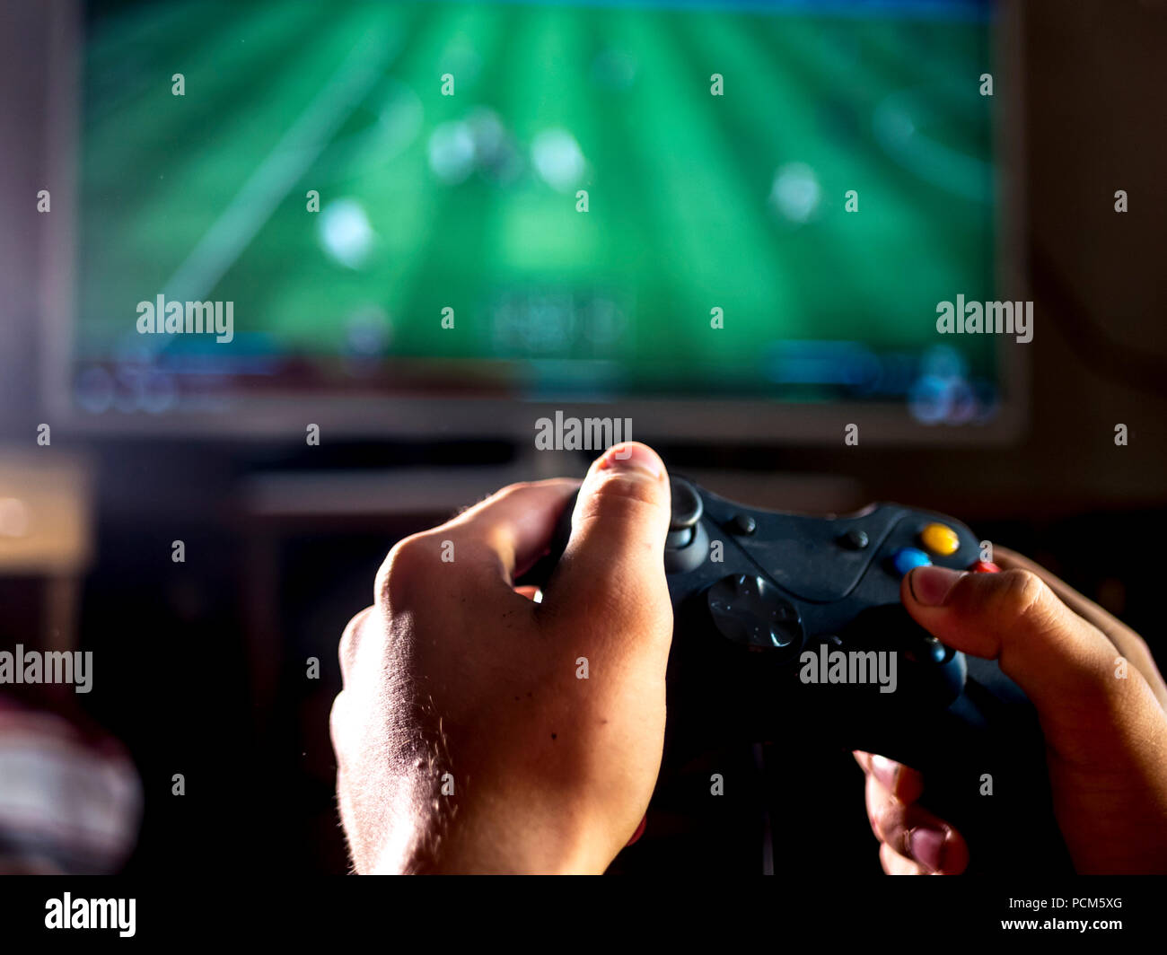 close up young man with joystick controller for console playing sport ...