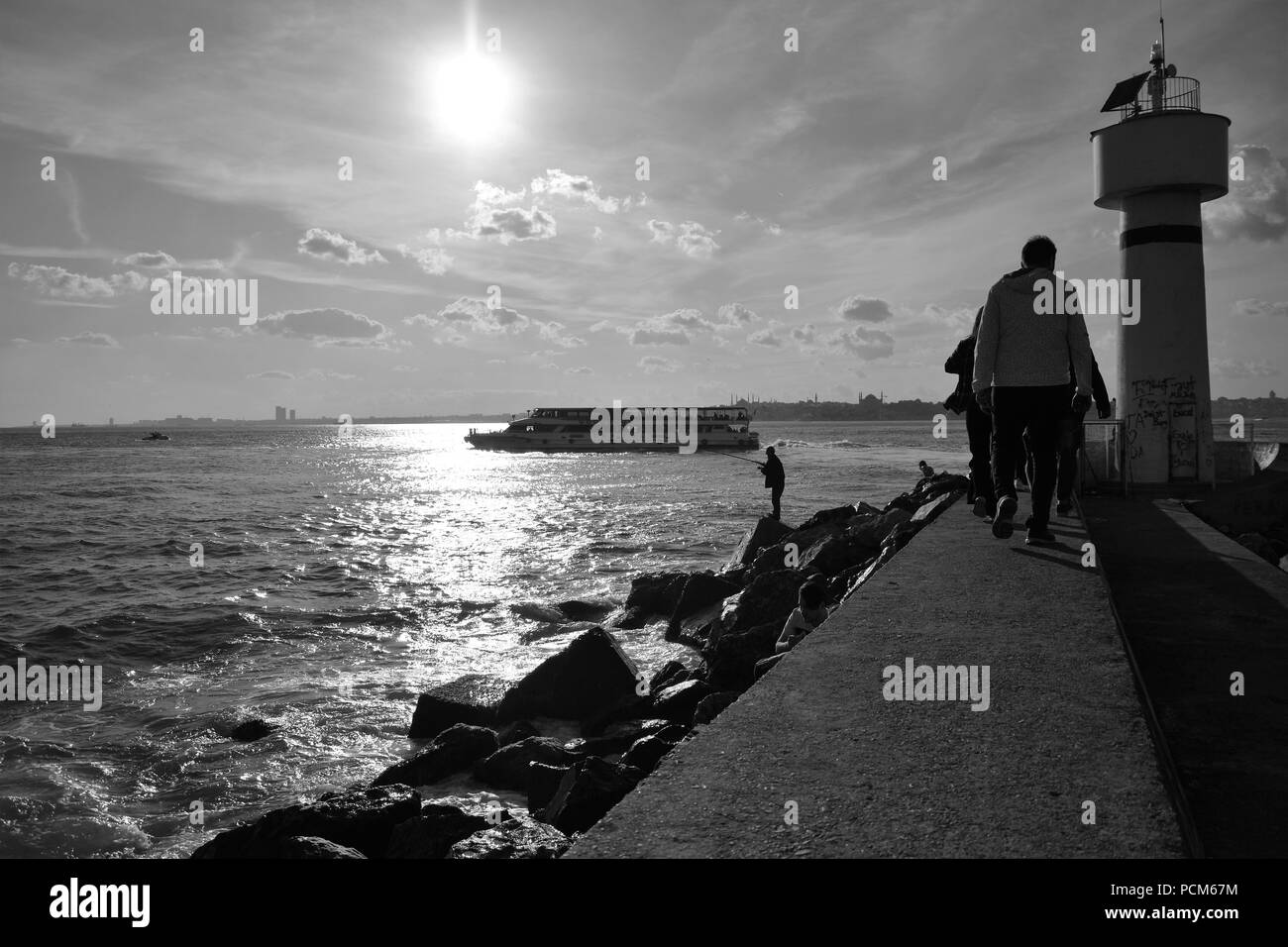People hanging around Kadikoy Lighthouse on a sunny day and the ...