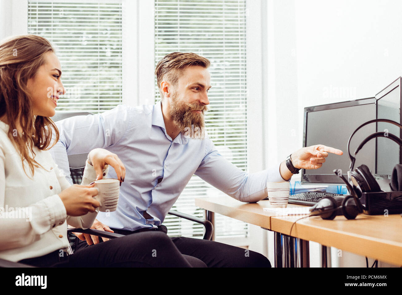 Image of happy young colleagues sitting in office coworking using ...