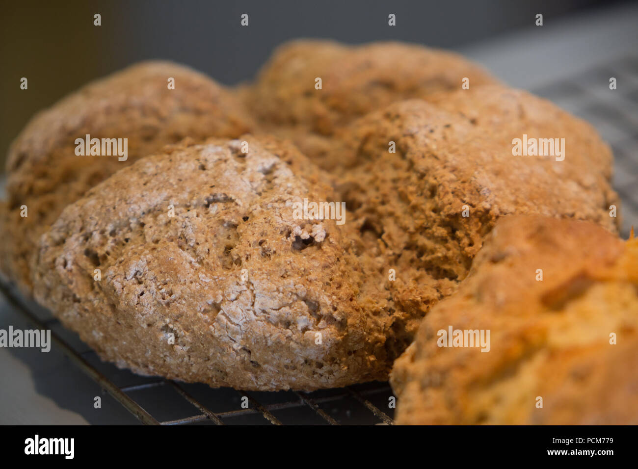 A loaf of cross-cut, Irish wheaten bread on a wire cooling rack in the ...