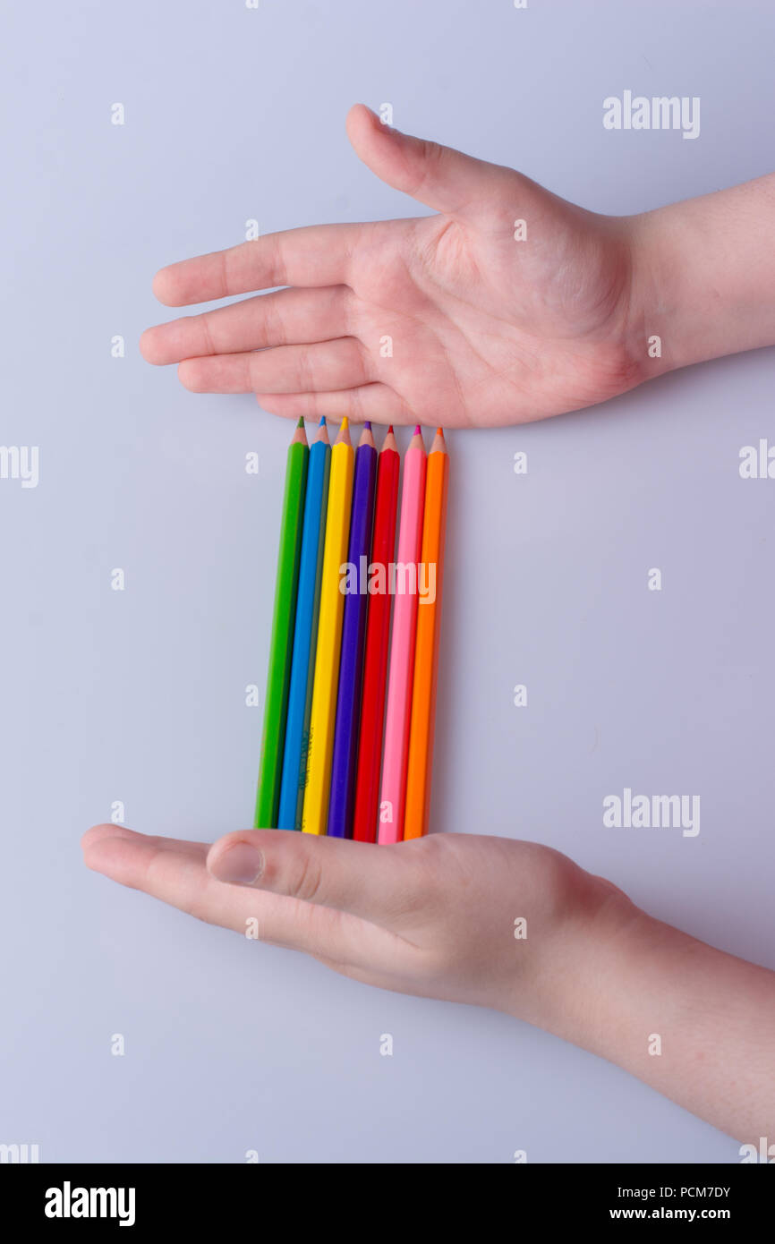 Hand holding color Pencils placed on a white background Stock Photo - Alamy