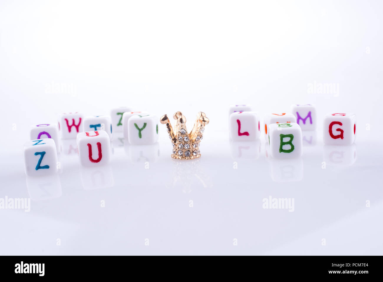 Crown between Letter cubes on a white background Stock Photo - Alamy