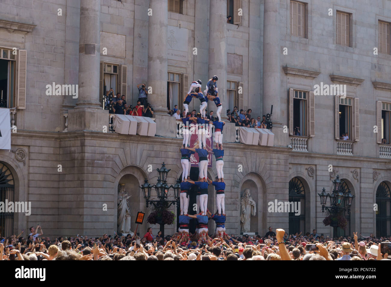 people building a human pyramid during the festival in catalunya, spain ...