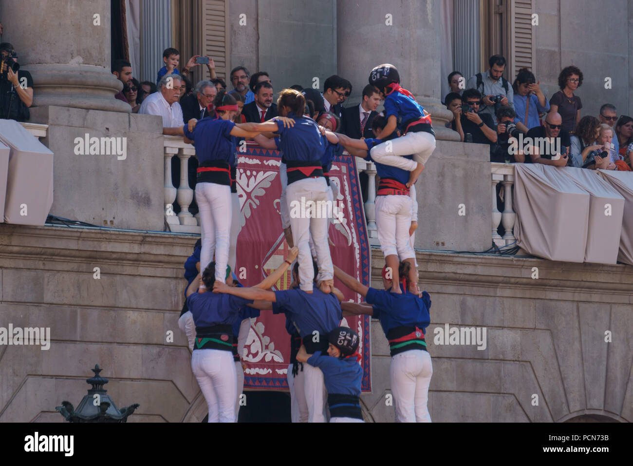 people building a human pyramid during the festival in catalunya, spain ...