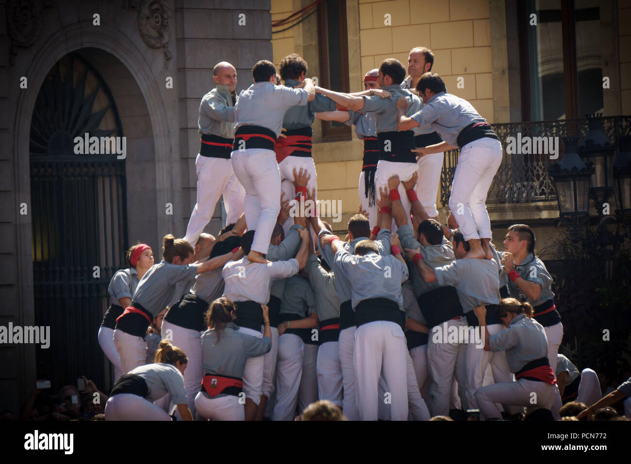 people building a human pyramid during the festival in catalunya, spain ...
