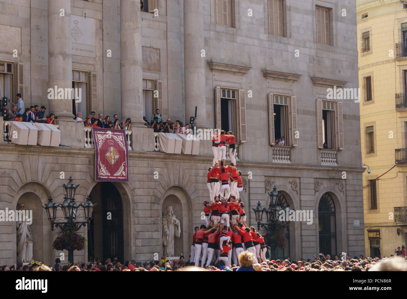 people building a human pyramid during the festival in catalunya, spain ...