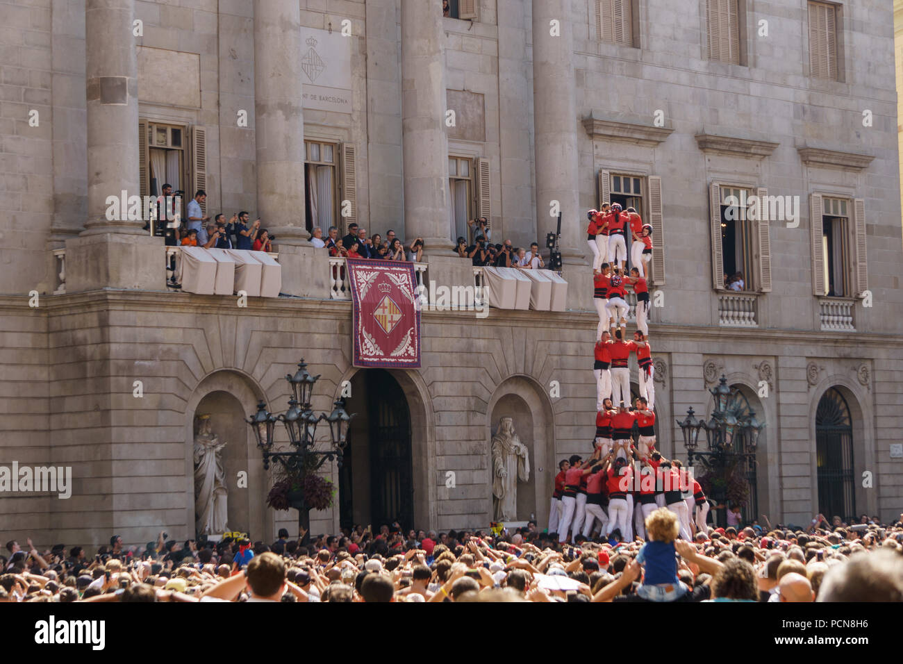 people building a human pyramid during the festival in catalunya, spain ...