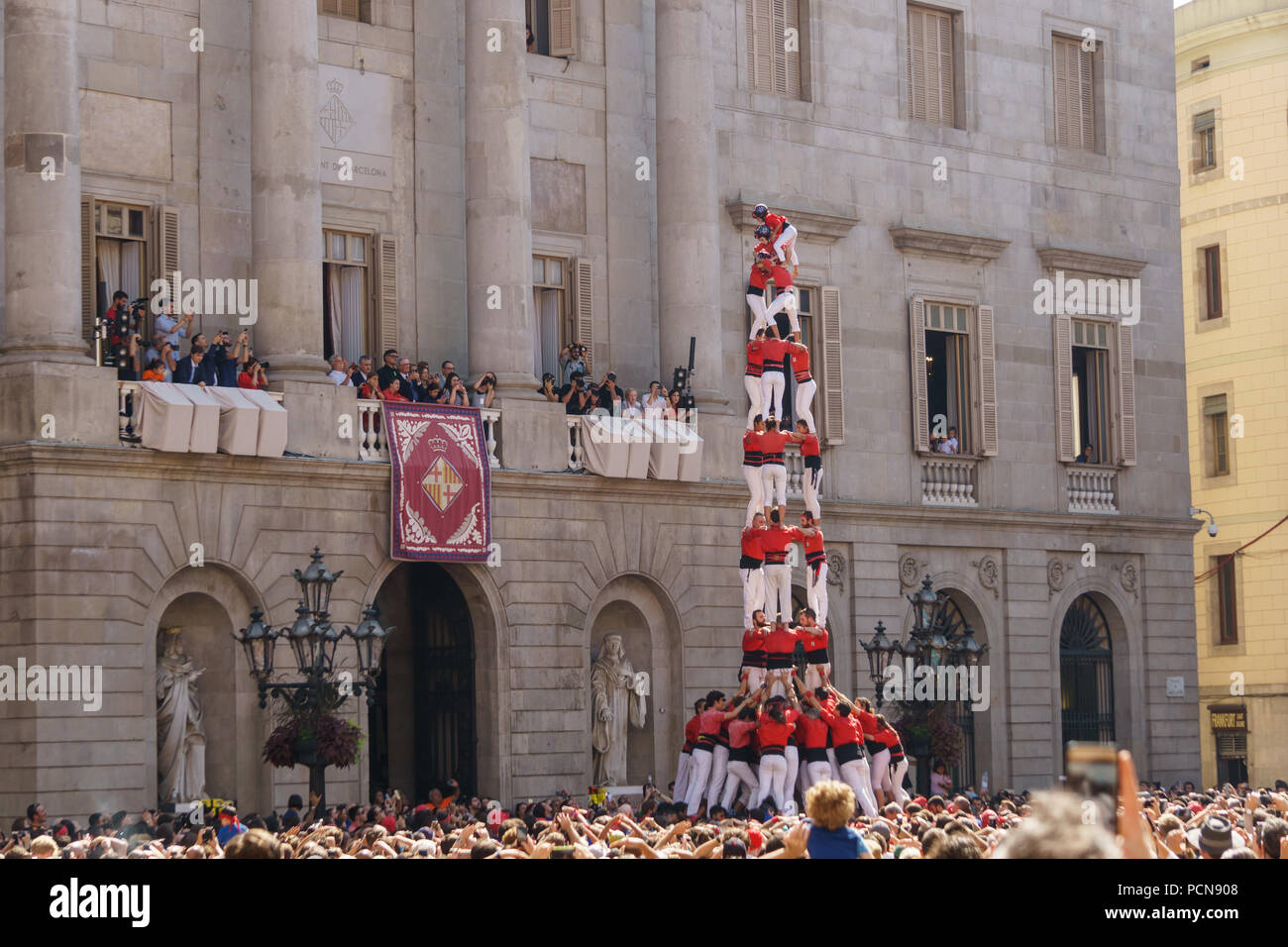 people building a human pyramid during the festival in catalunya, spain ...