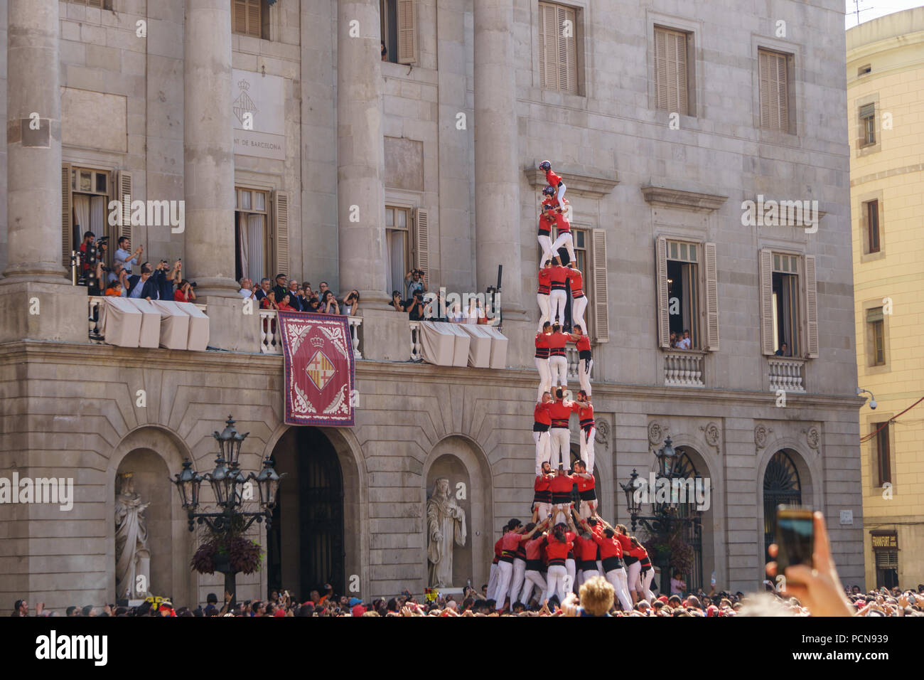 people building a human pyramid during the festival in catalunya, spain ...