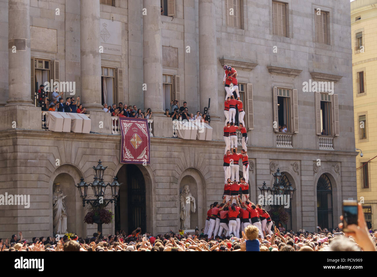 people building a human pyramid during the festival in catalunya, spain ...