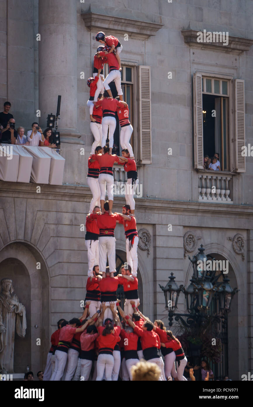 people building a human pyramid during the festival in catalunya, spain ...