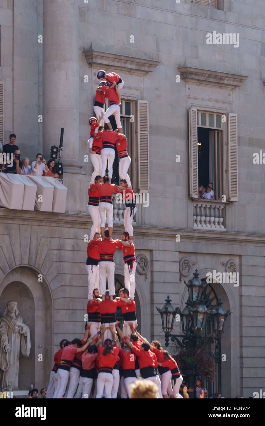 people building a human pyramid during the festival in catalunya, spain ...