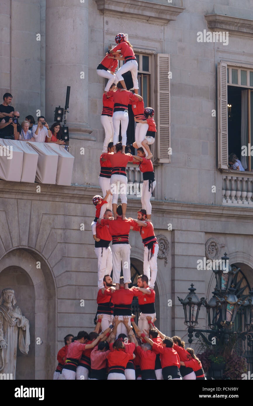 people building a human pyramid during the festival in catalunya, spain ...