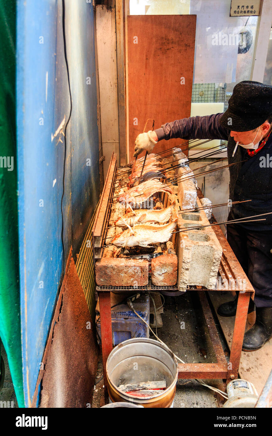 Kuromon Ichiba, Osaka's kitchen food market. Senior man, smoking ...