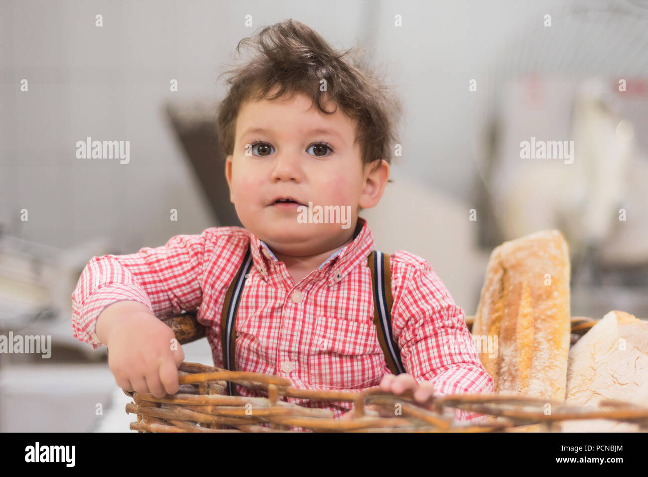 Portrait of a cute baby inside a basket with bread in the bakery Stock ...