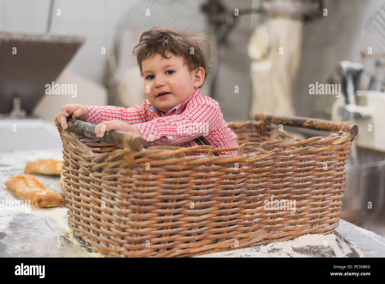 Portrait of a cute baby inside a basket with bread in the bakery Stock ...
