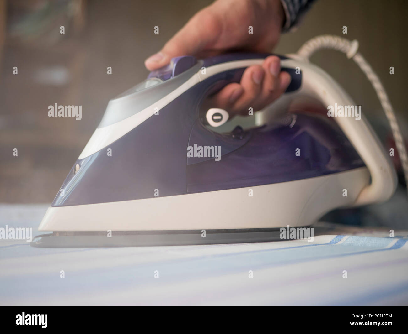 close up maid hand in the hotel ironing clothes in hotel room on white ...