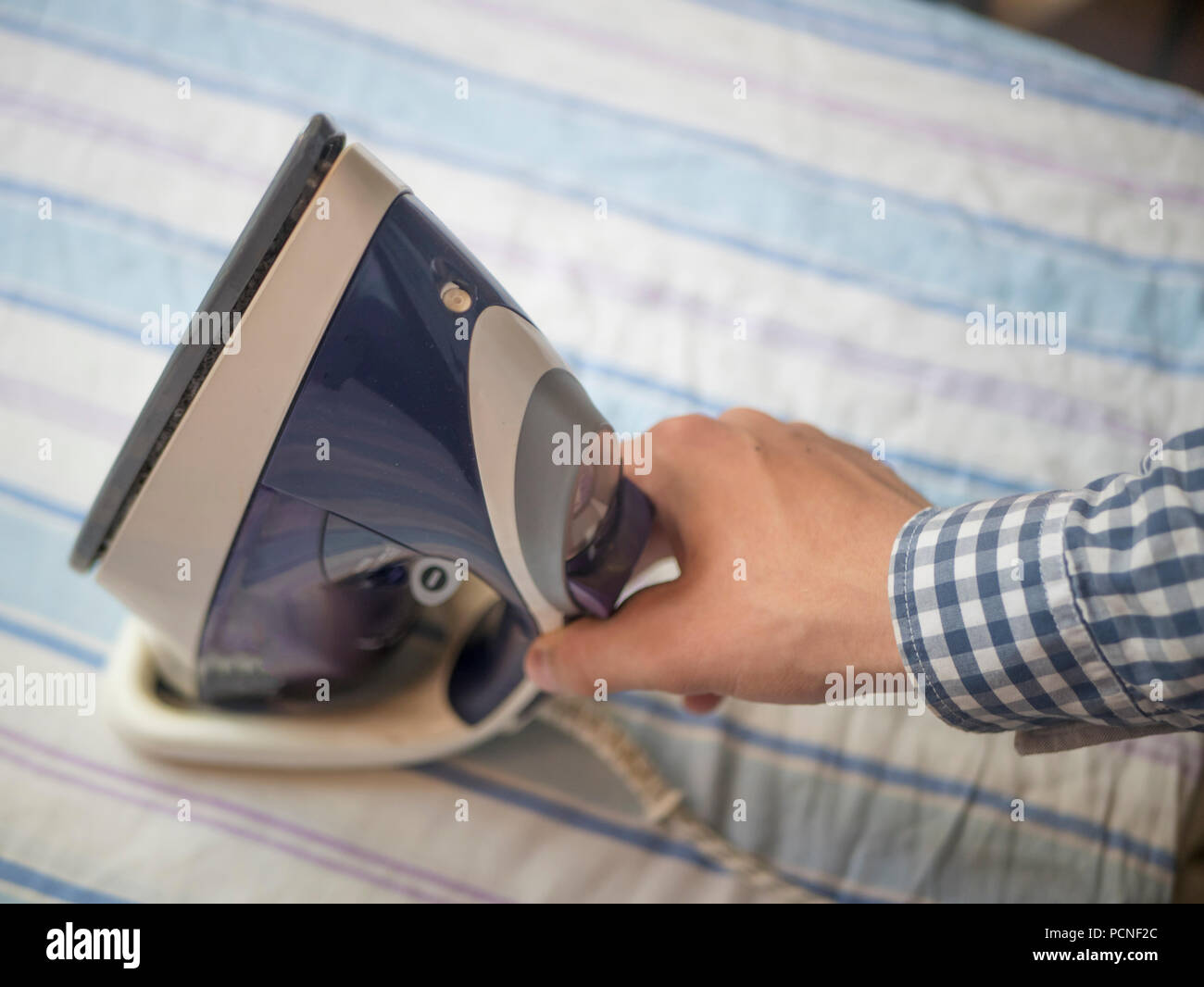 close up female hand hold iron above the table at cozy home Stock Photo ...