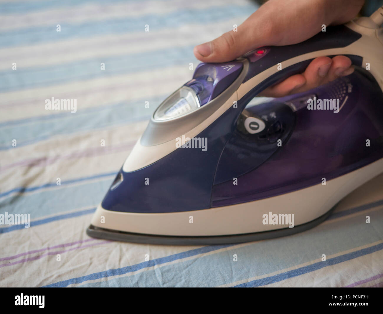 close up person holding iron on the table isolated Stock Photo - Alamy