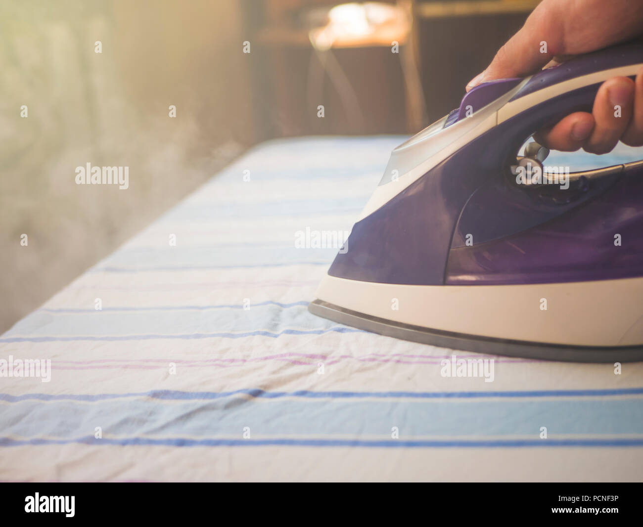 close up person holding iron on the table isolated Stock Photo - Alamy