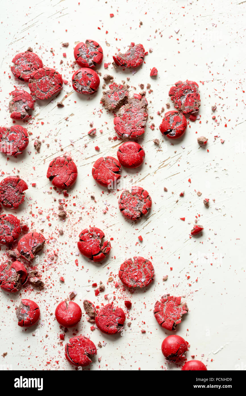 Smashed red coated chocolate candy Stock Photo - Alamy