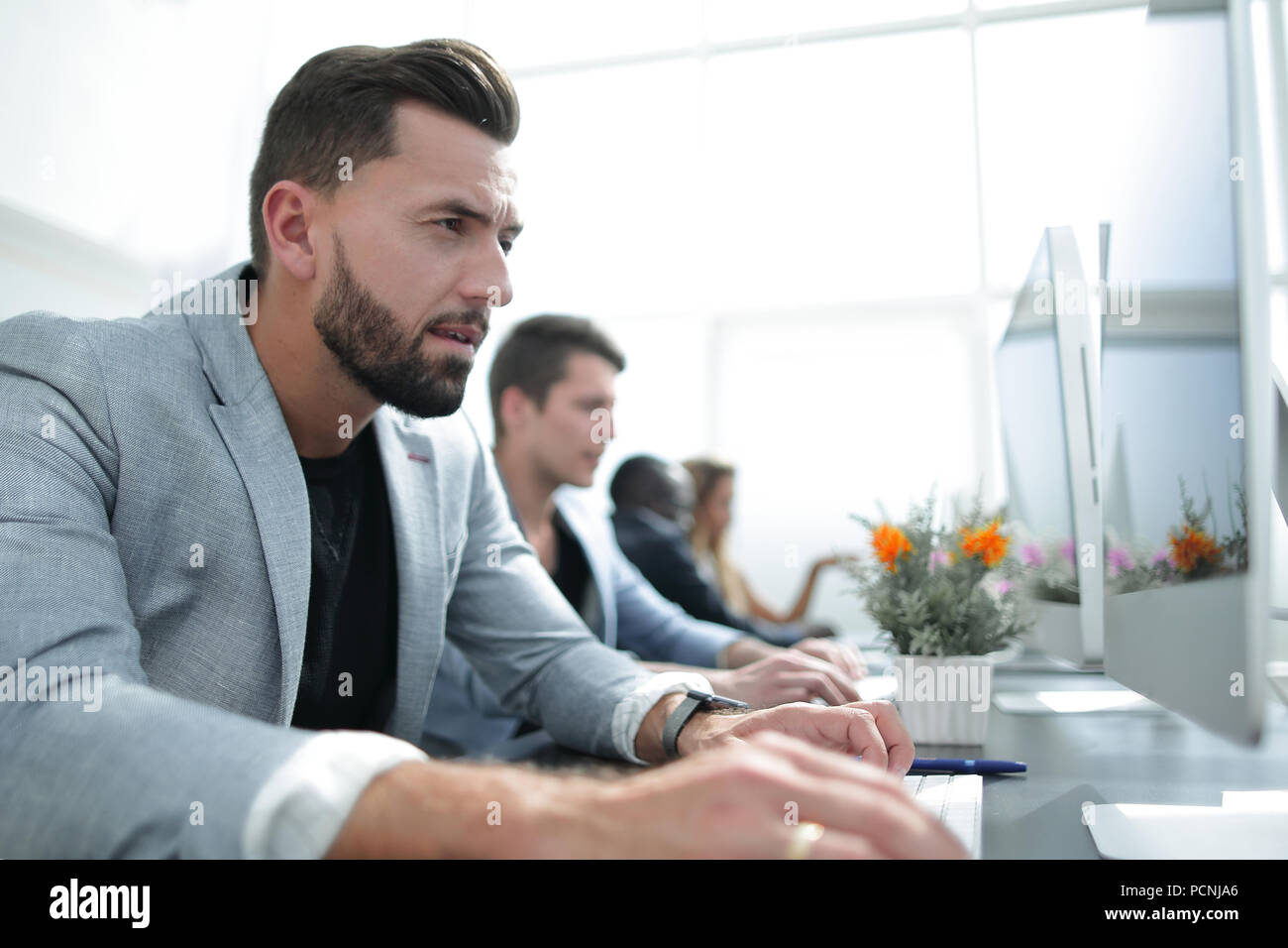 businessman sitting at a table in the computer room Stock Photo - Alamy