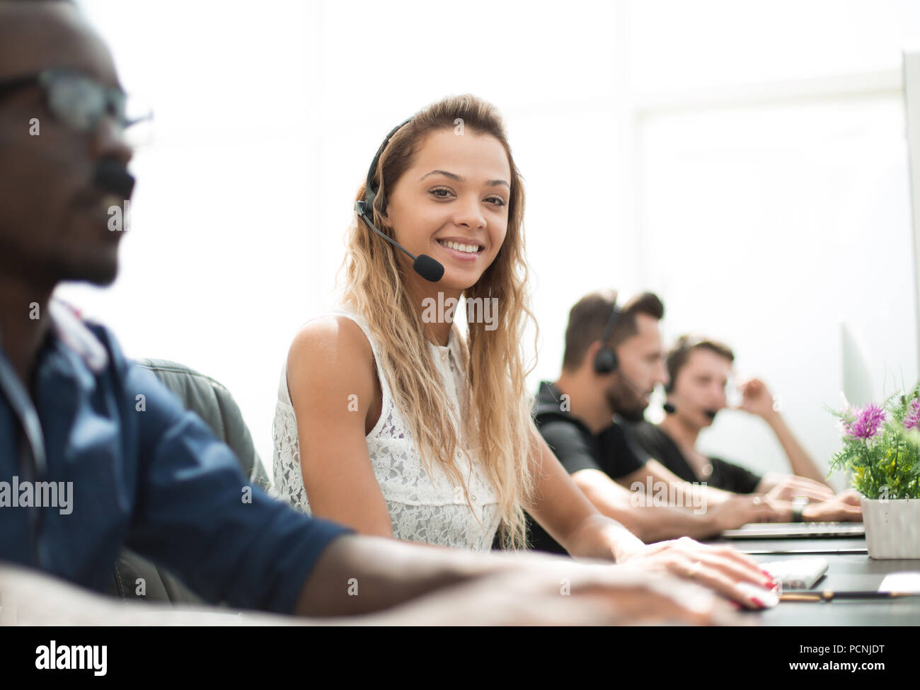 smiling call center employee sitting at his Desk Stock Photo - Alamy