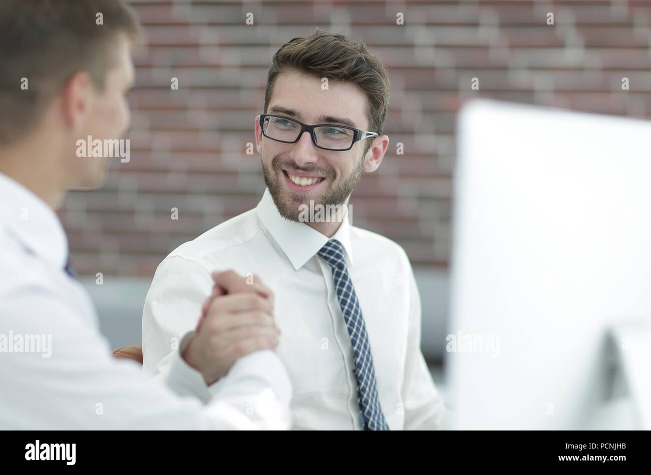 handshake of the employees at the Desk Stock Photo - Alamy