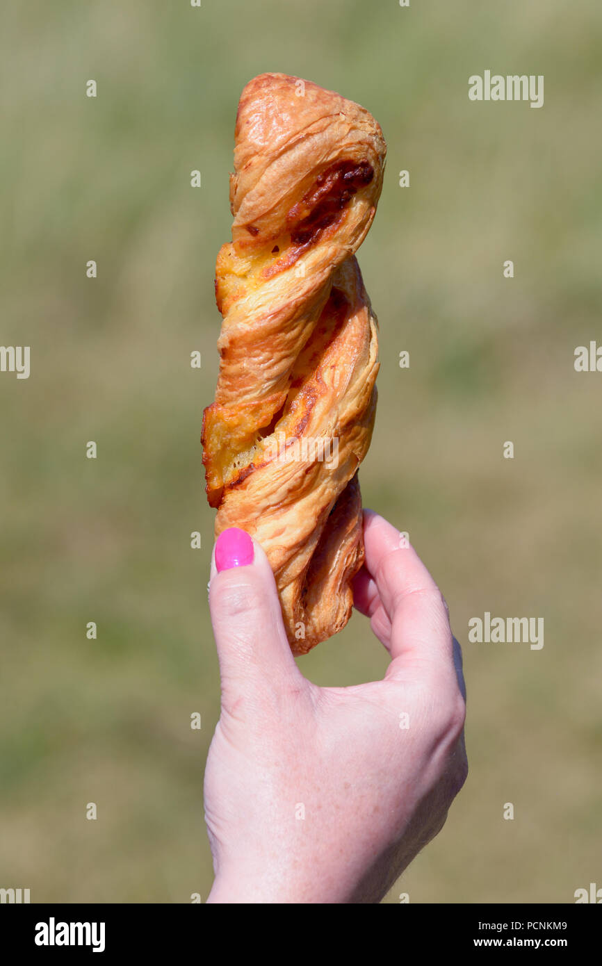 Woman holding cheese straw pastry in her hand Stock Photo - Alamy