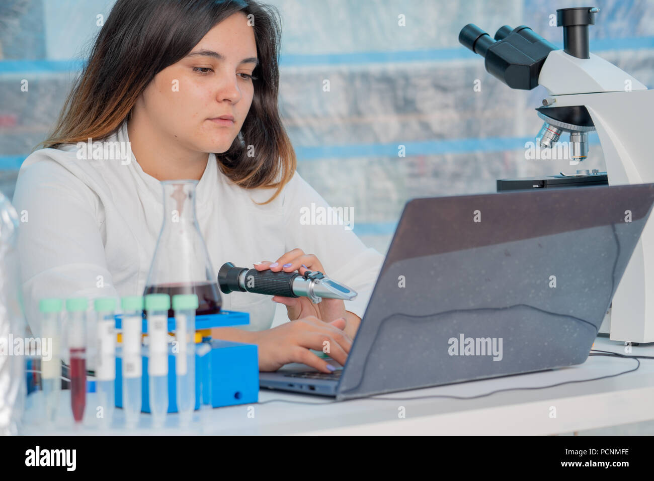 Young female technician in the quality control laboratory of wine ...