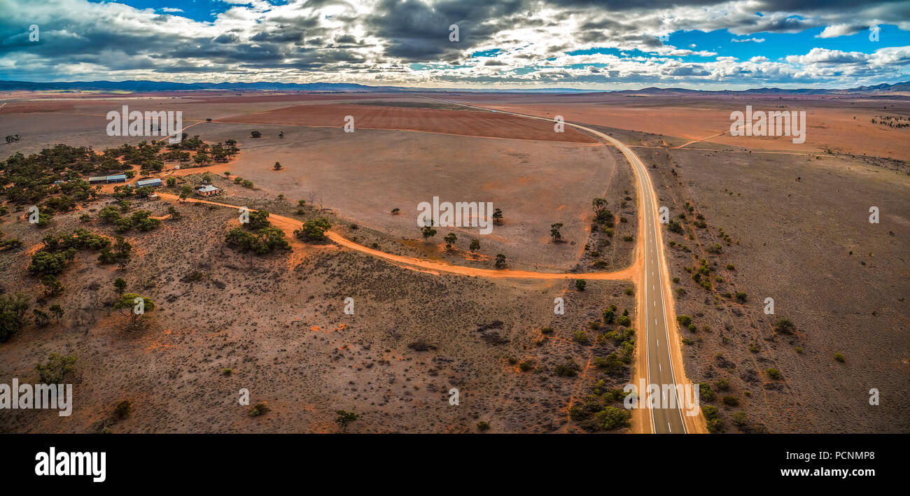 Rural highway bend in Australian outback under beautiful skies - aerial ...