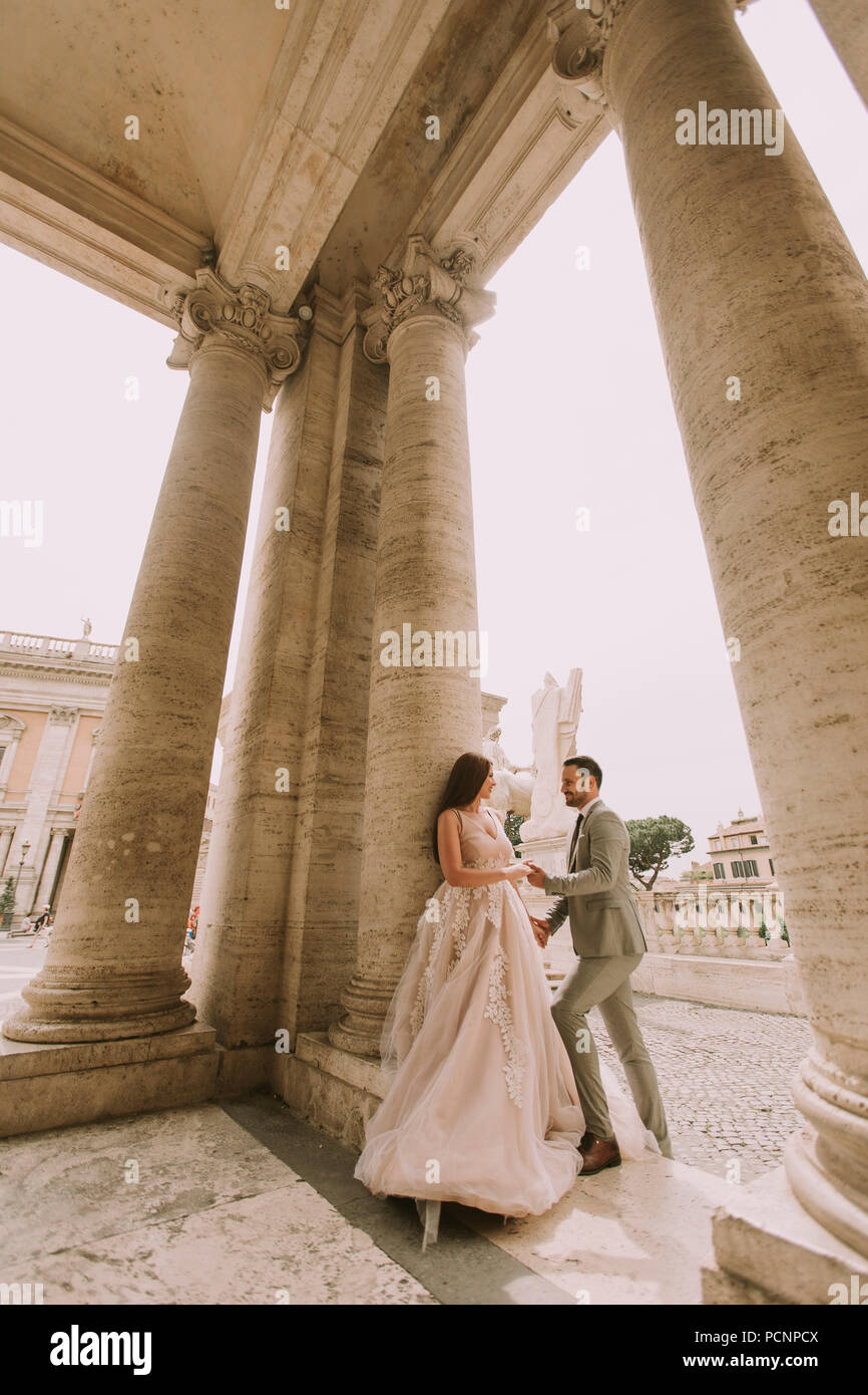 Young attractive newly married couple posing in Rome with beautiful and ...