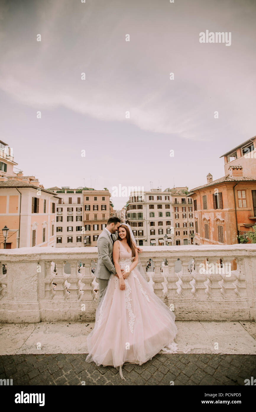 Young attractive newly married couple posing in Rome with beautiful and ...