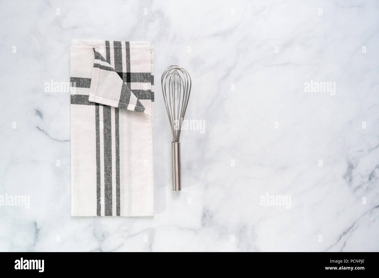 New kitchen towels with simple black pattern folded on marble counter ...