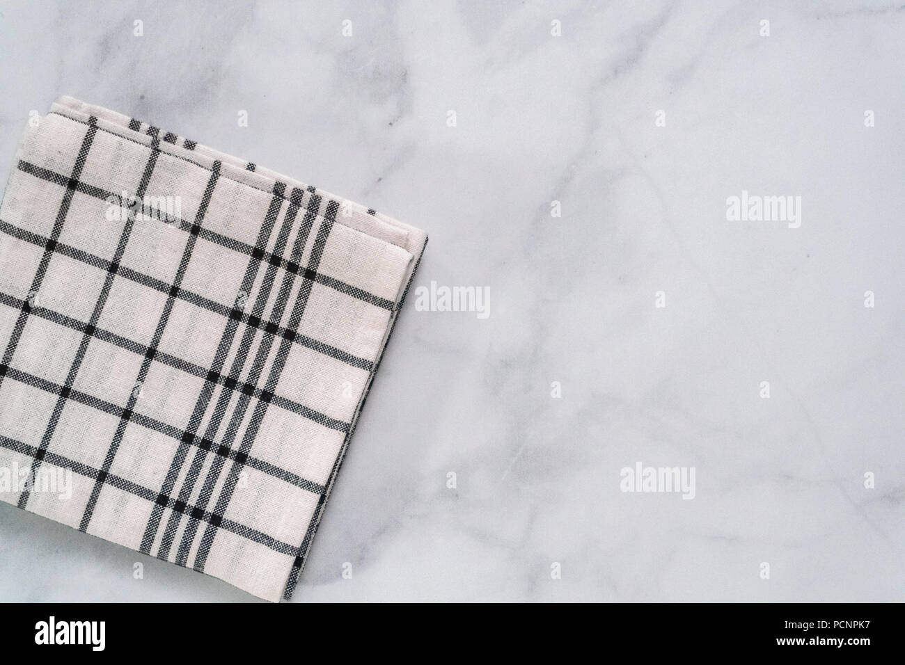 New kitchen towels with simple black pattern folded on marble counter ...