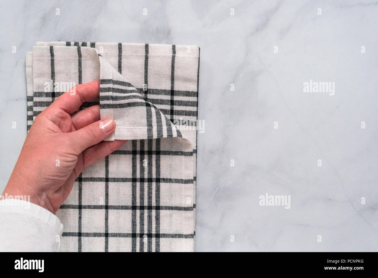 New kitchen towels with simple black pattern folded on marble counter ...