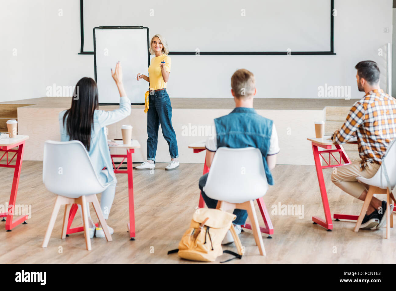rear view of group of young students listening lecture together Stock ...