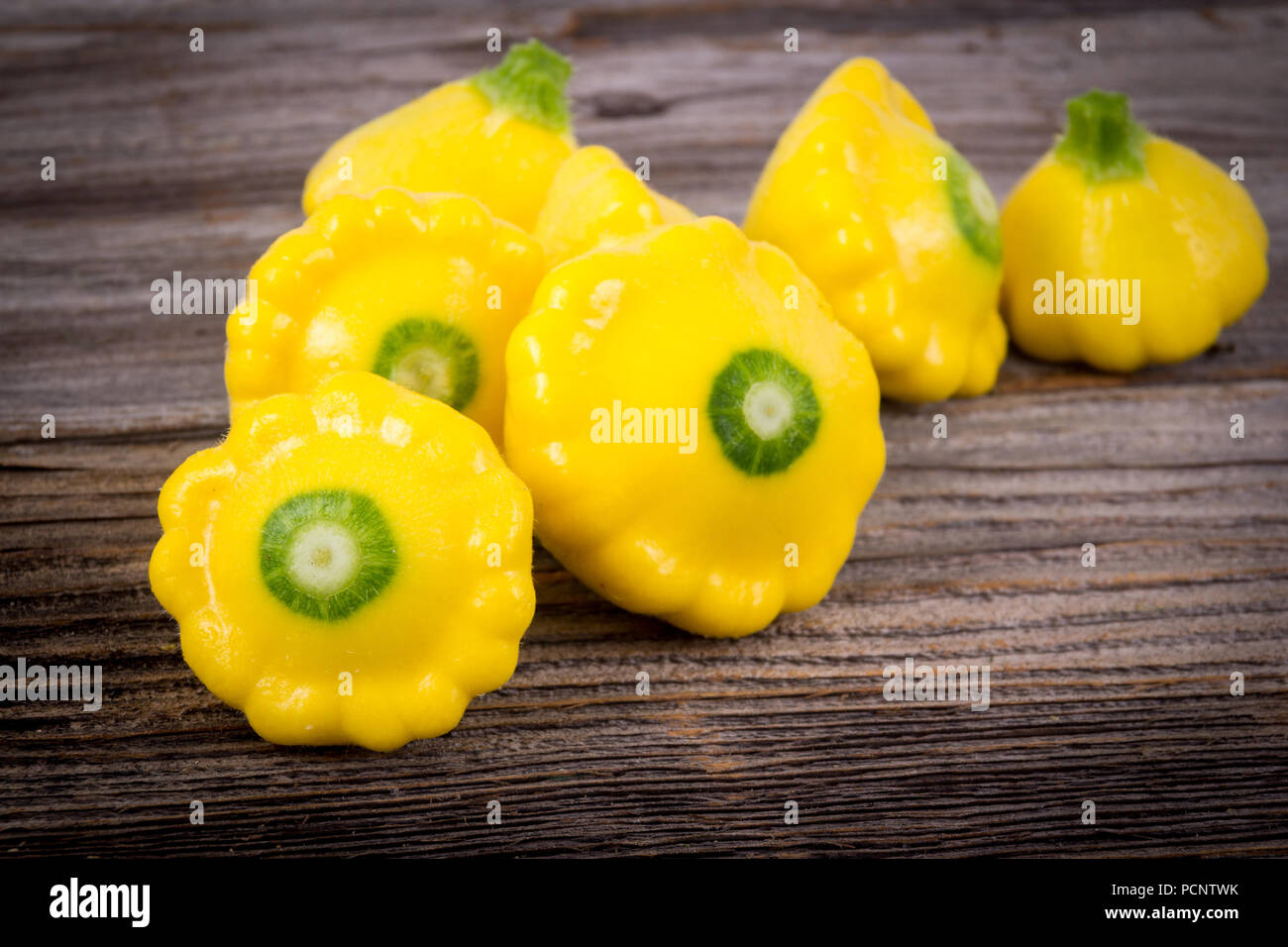 small size patty pan patisson squash wood background Stock Photo - Alamy